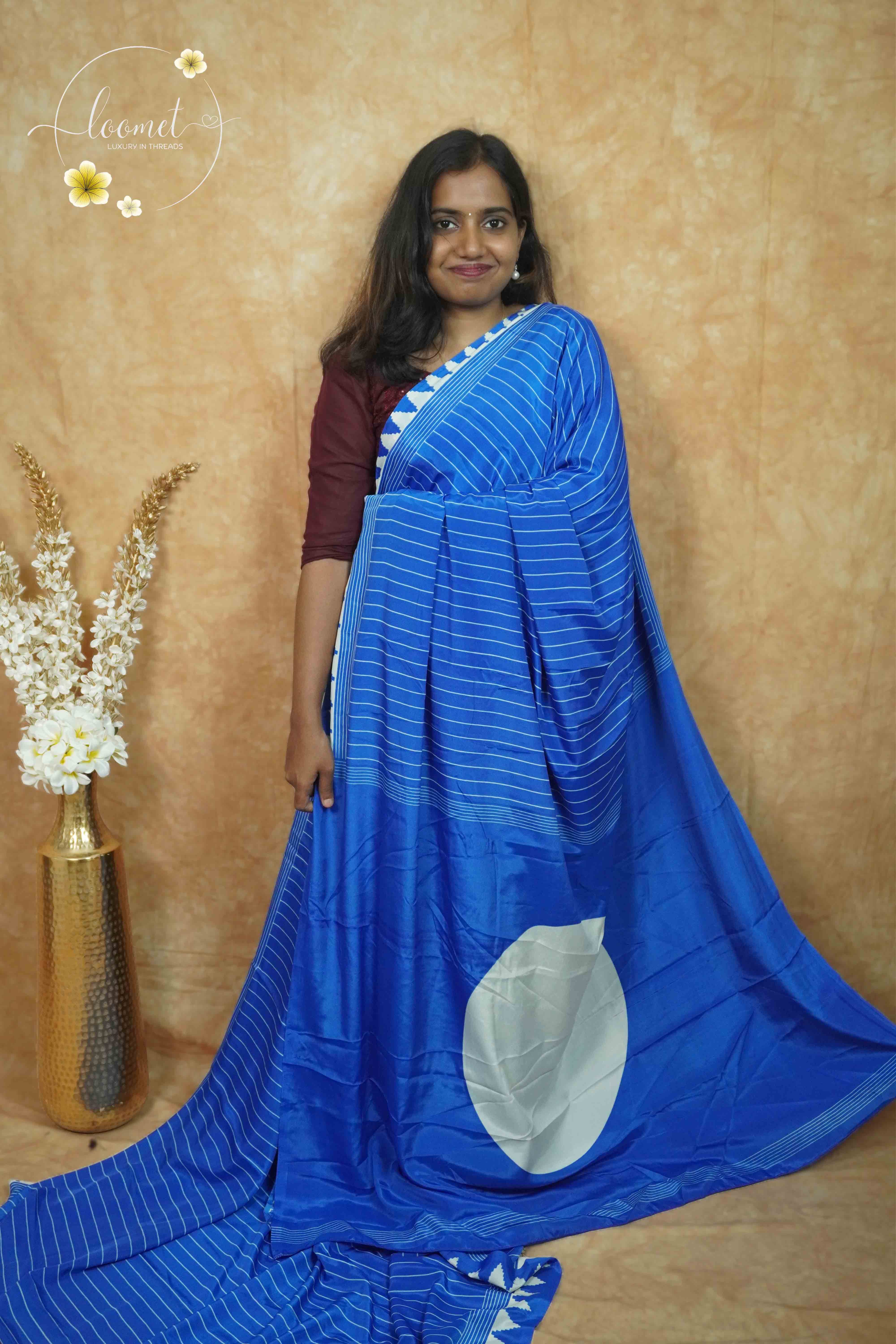 APL8603 Blue saree features thin white horizontal stripes, a white tri ...